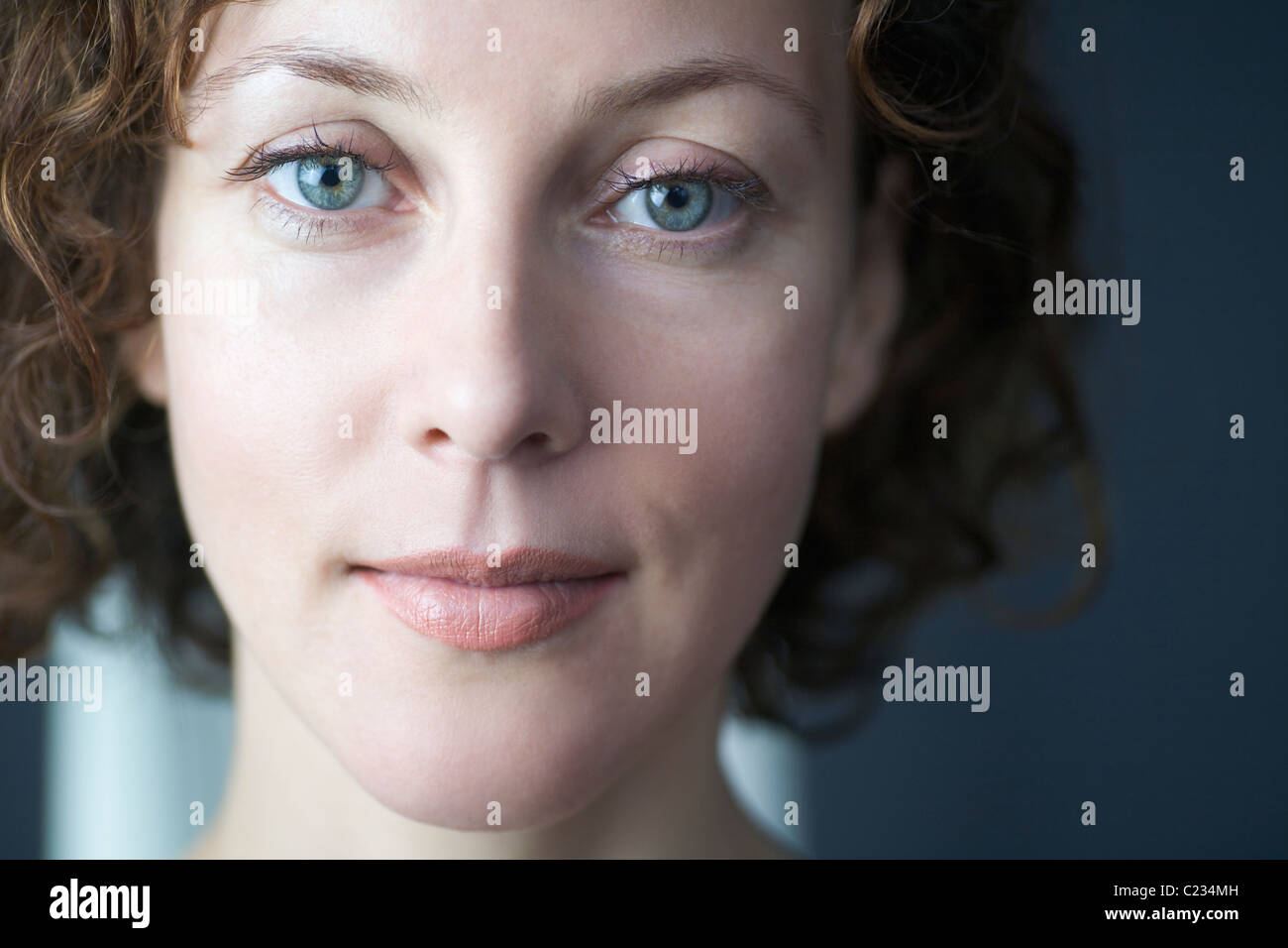 Mid adult woman looks directly at camera Stock Photo - Alamy