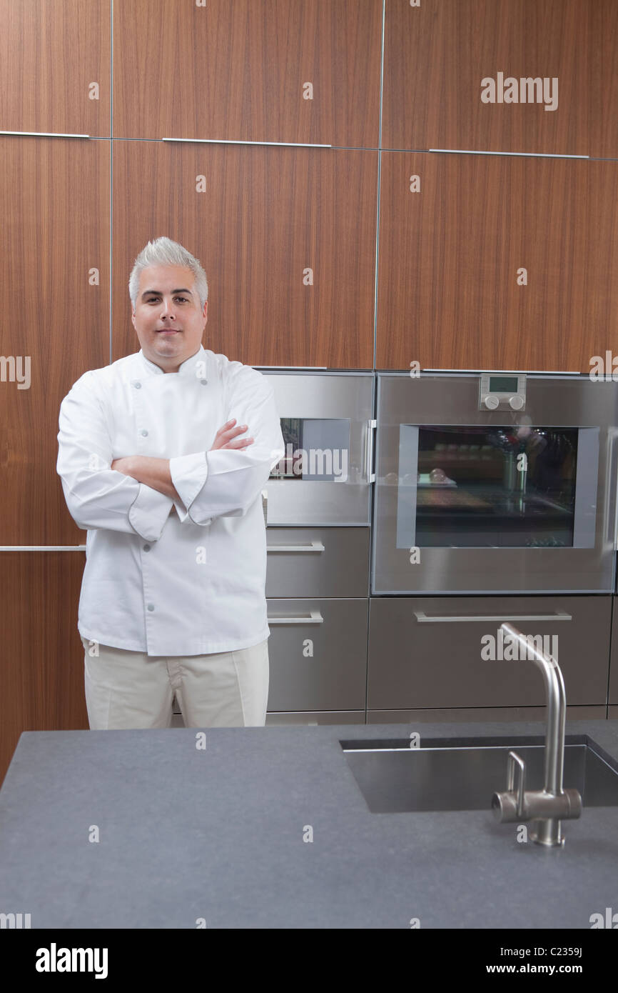 Mid- adult chef stands with arms folded Stock Photo - Alamy