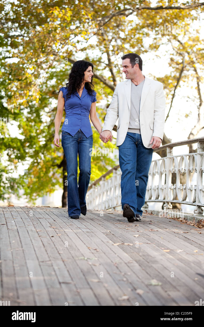 A couple walking on a bridge in a park Stock Photo - Alamy
