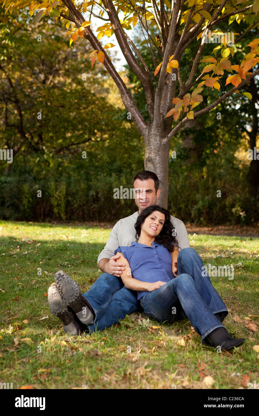 A couple relaxing in the park by a tree Stock Photo - Alamy