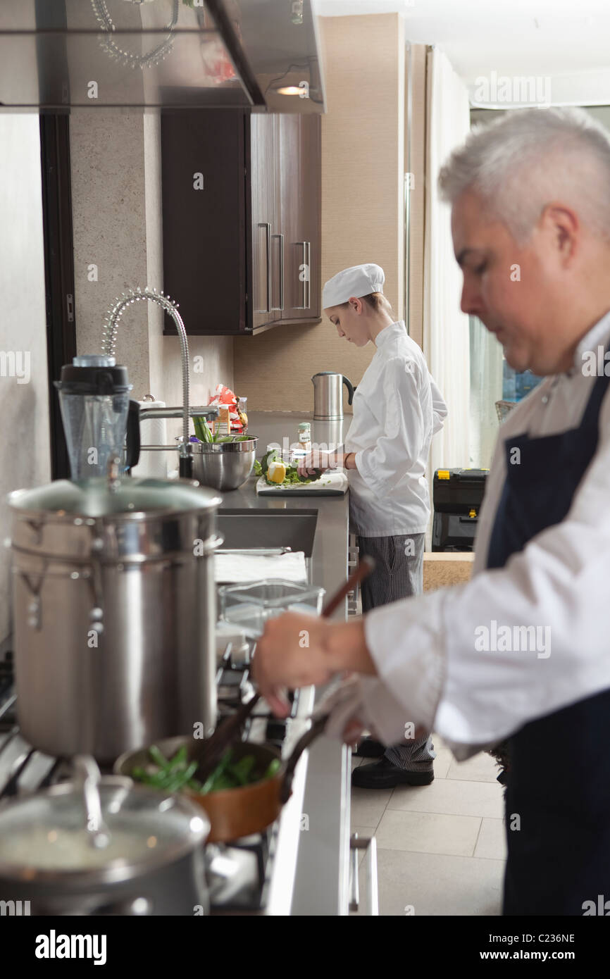 Chef heating pan on hob Stock Photo - Alamy
