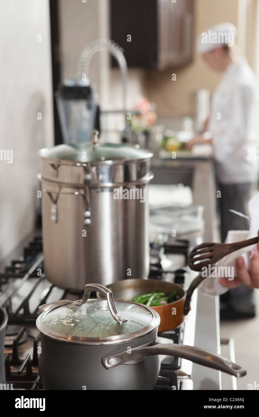 Chef heating saucepan on hob Stock Photo - Alamy