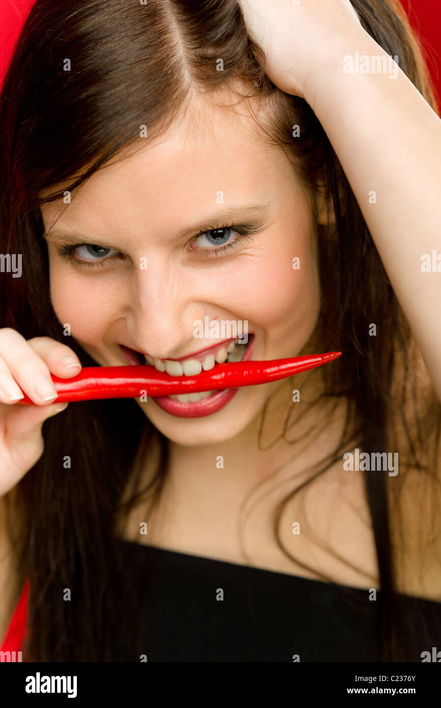 Chili pepper - portrait young woman bite red spicy vegetable Stock ...