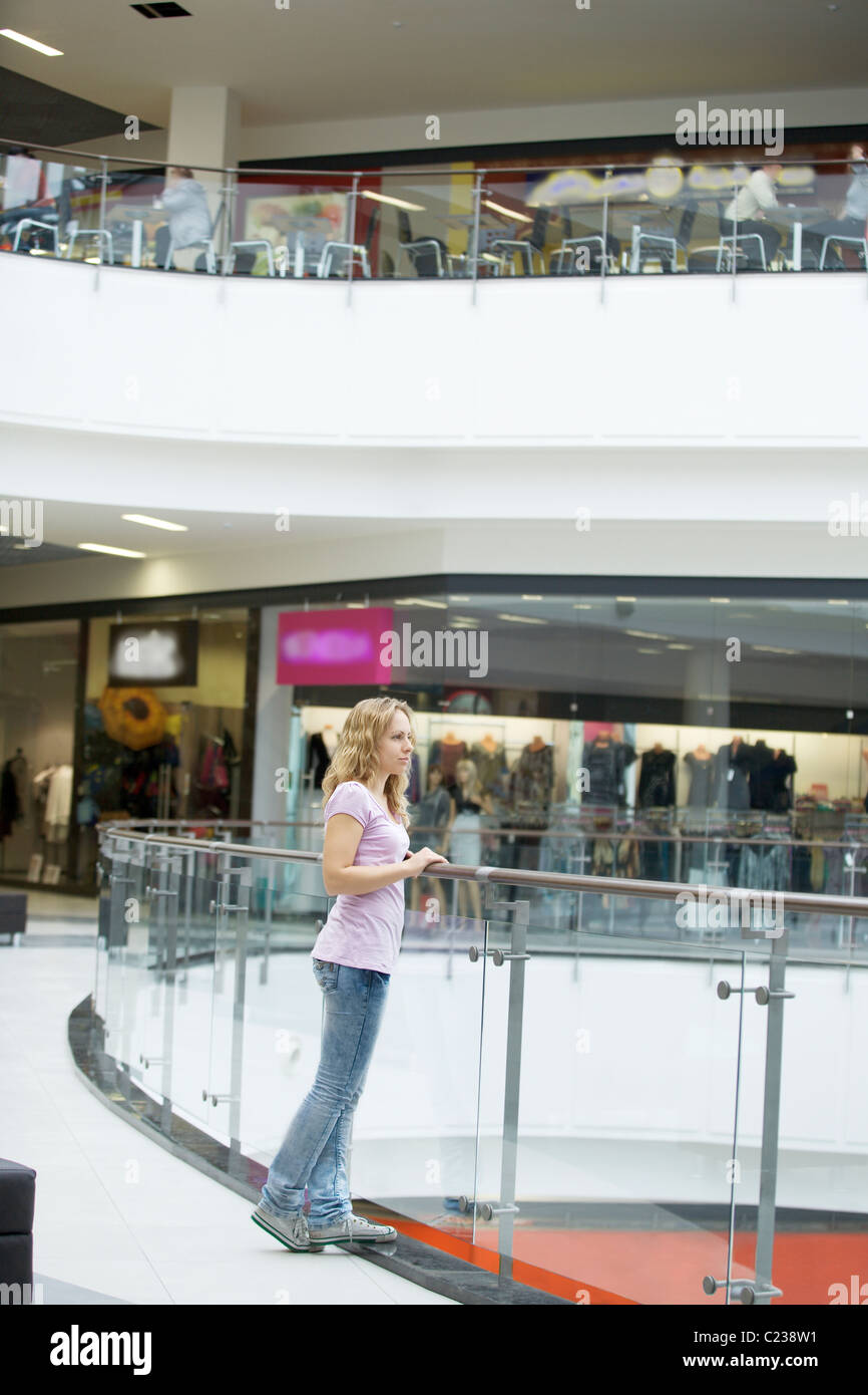 Young woman stands looking over balcony in shopping centre Stock Photo ...