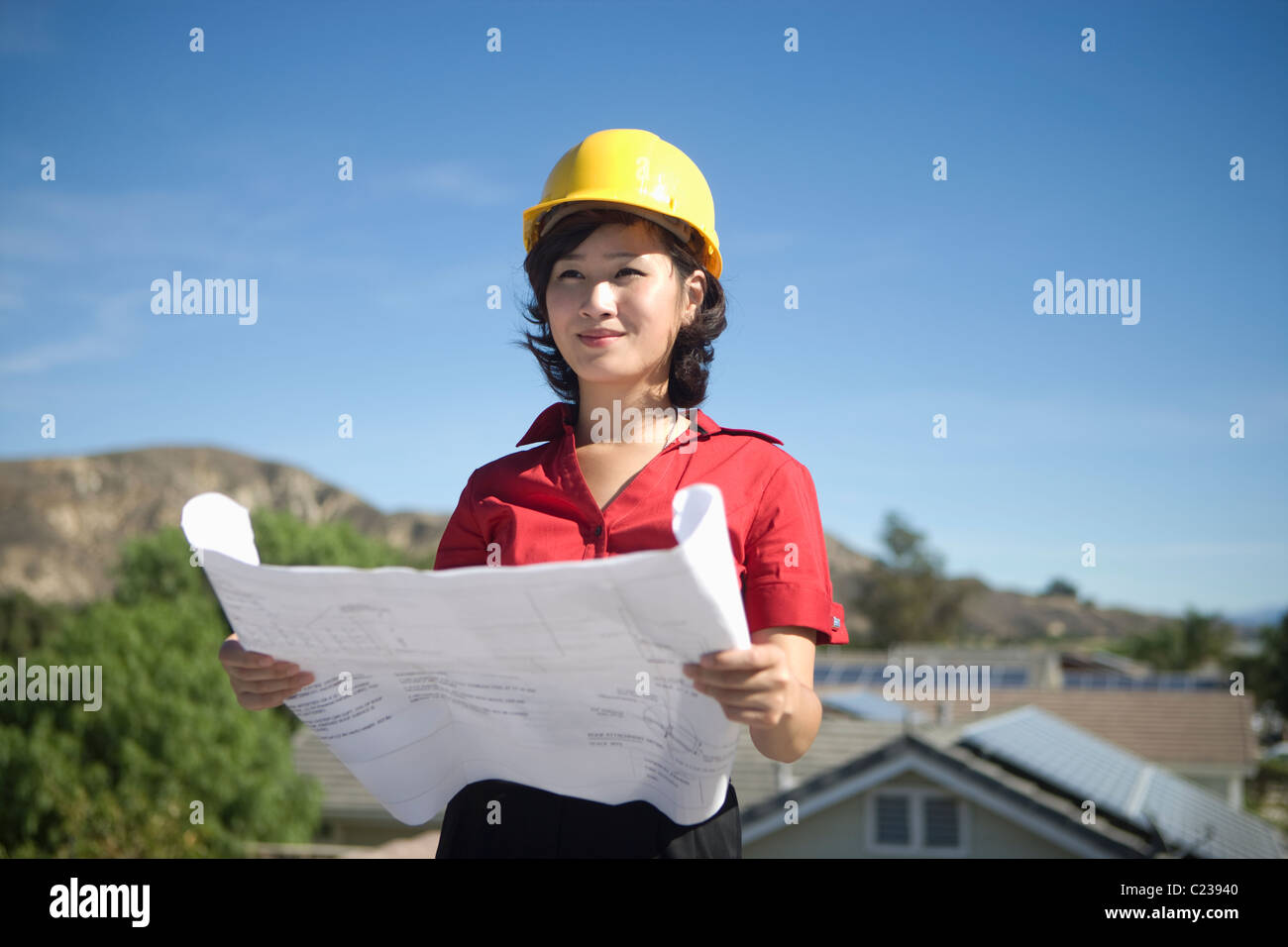 A business lady on a rooftop with plans in her hand Stock Photo - Alamy
