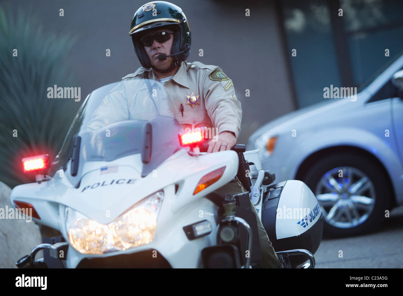 Patrol officer sits on motorcycle with hazrd lights lit Stock Photo - Alamy