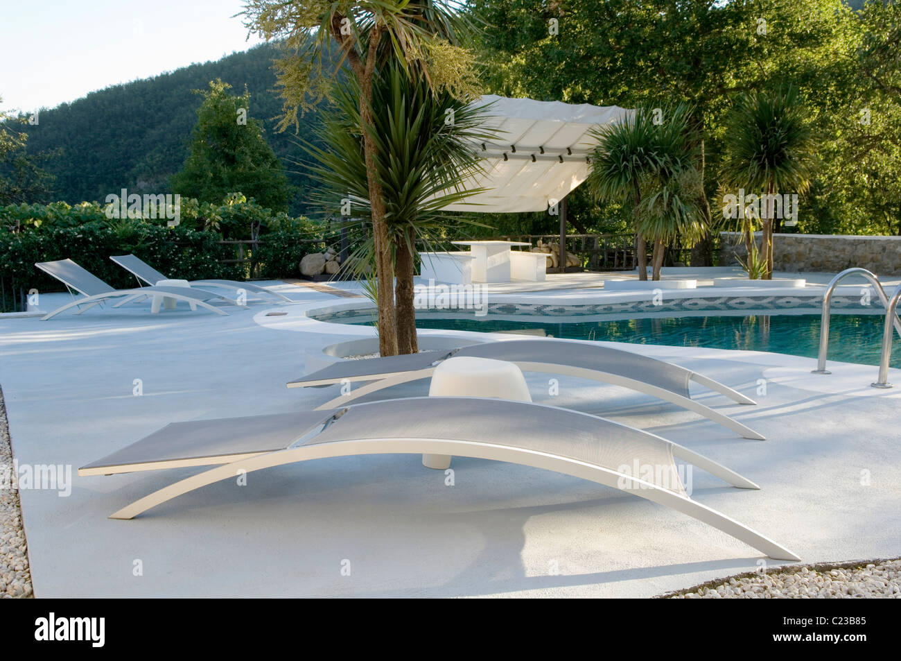 Modern sunloungers on stone terrace of outdoor swimming pool Stock ...