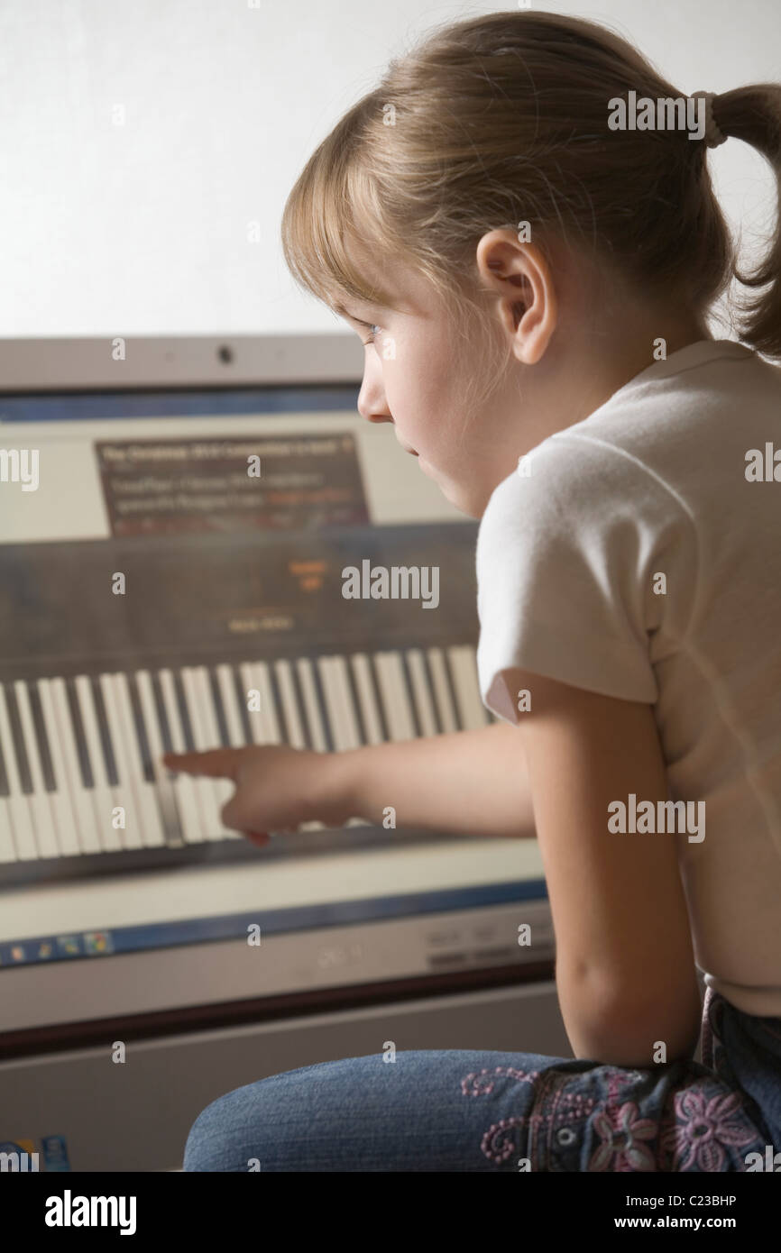 Child leans keywboard on computer with touch screen technology Stock ...