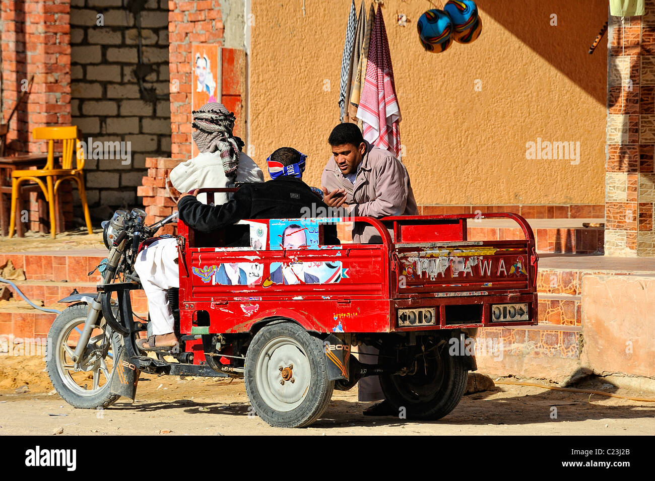 Egyptian man driving a motorcycle in a street of the town of Siwa ...