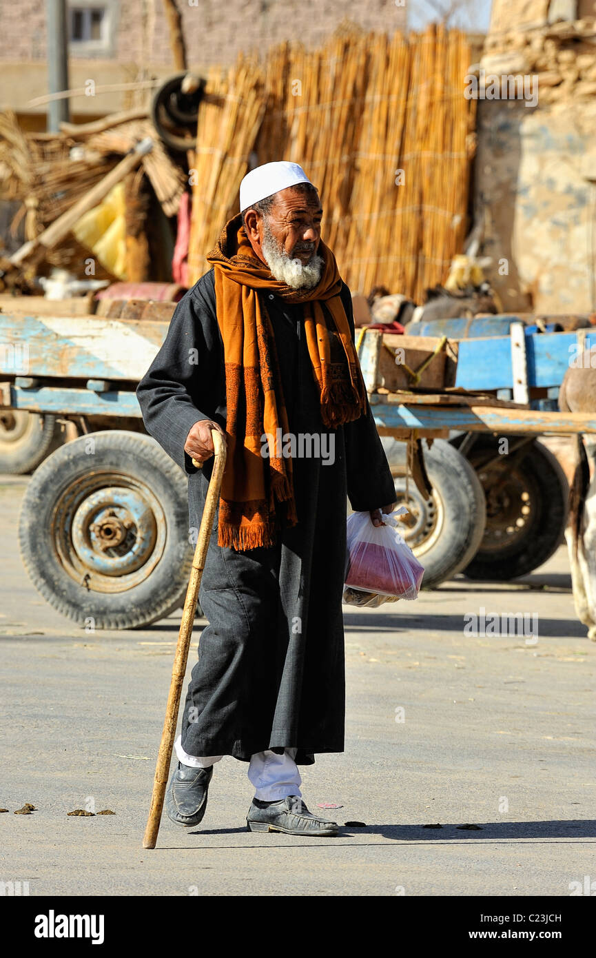 Old Egyptian man wearing typical clothes and walking in a street in the ...