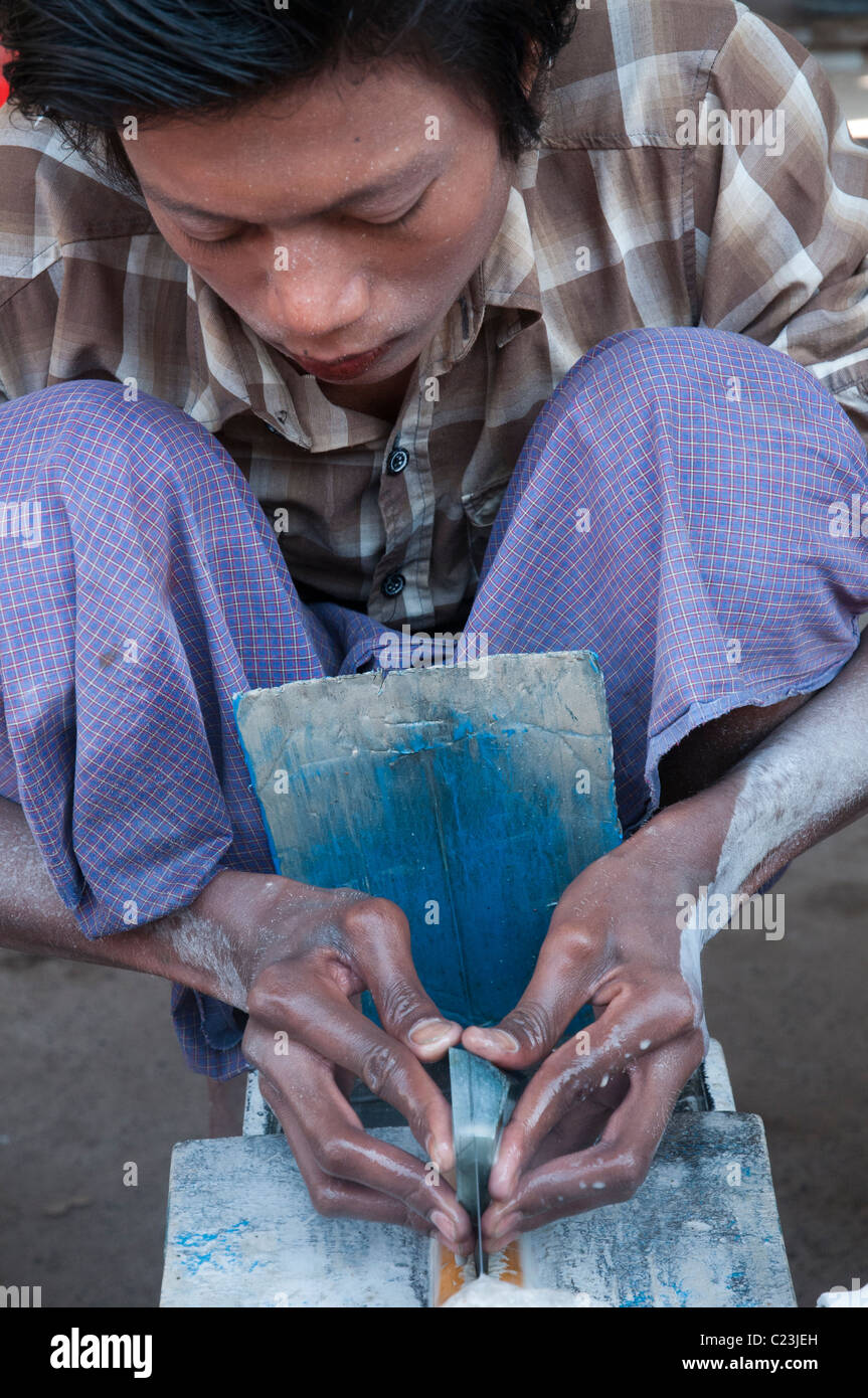 Young man cutting a slice of jade stone. jade market. Mandalay. Myanmar ...