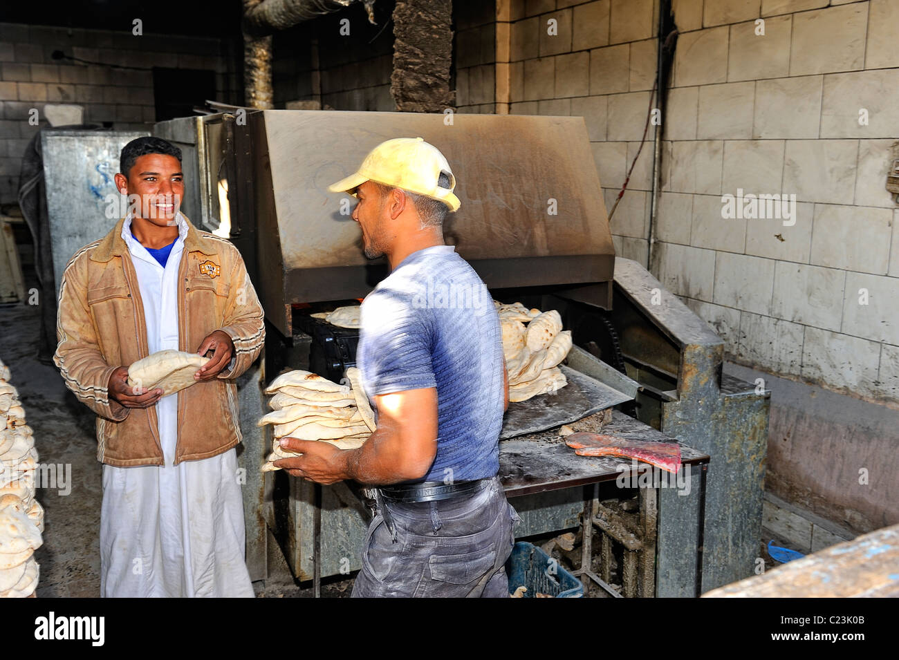 Baker preparing bread in a public bakery in the city of Siwa, western ...