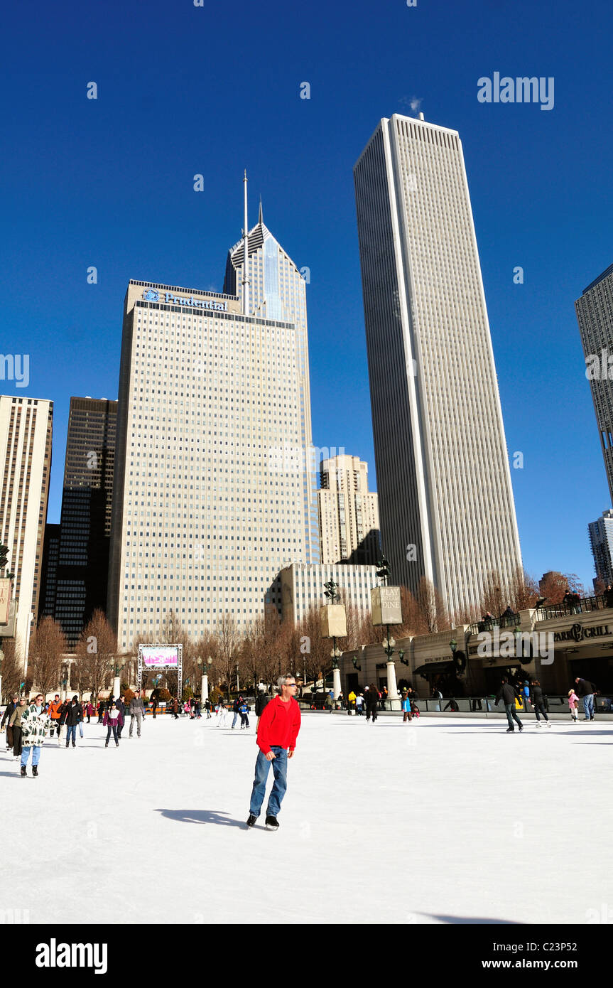 Skaters circle the ice rink in Millennium Park, the Prudential Building ...