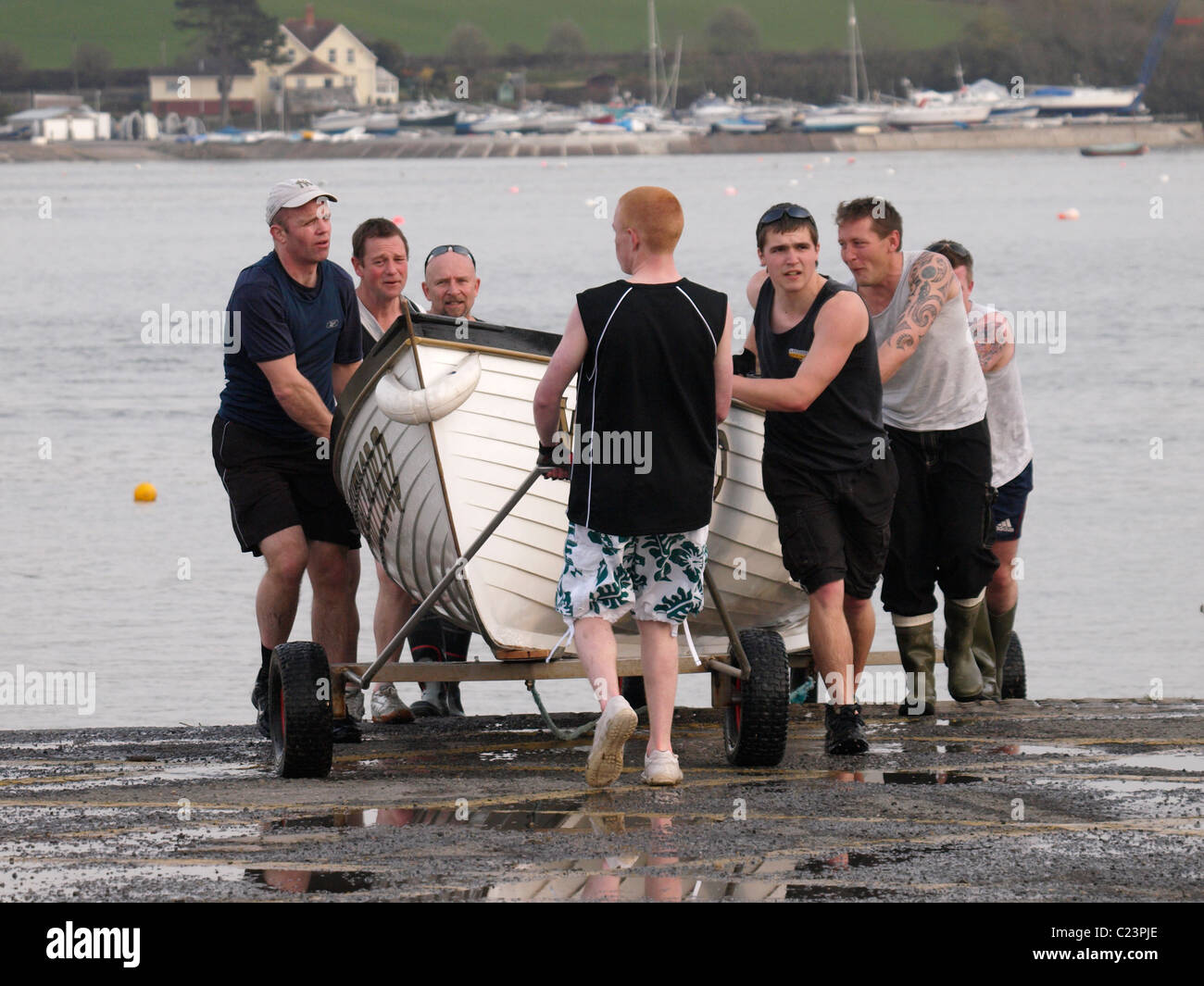 Gig boat crew pulling boat from water on trailer, Devon, UK Stock Photo ...