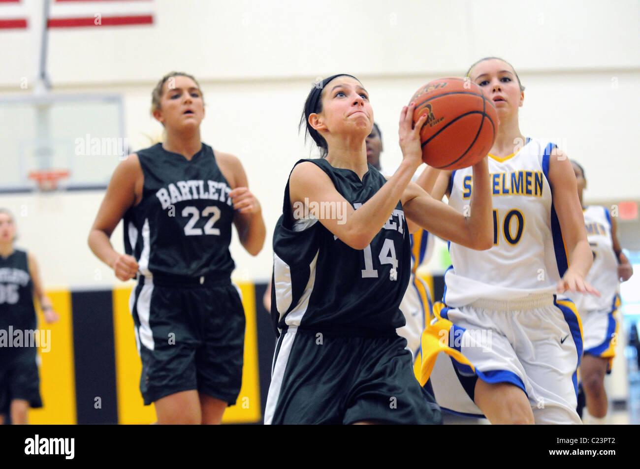 High school player takes the ball to the hoop to complete a drive ...