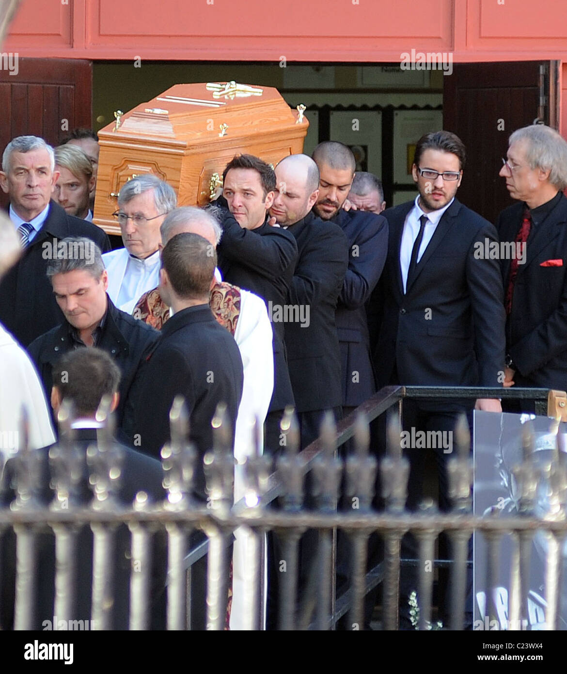 Ronan Keating, Mikey Graham and Shane Lynch of Boyzone carry the coffin ...