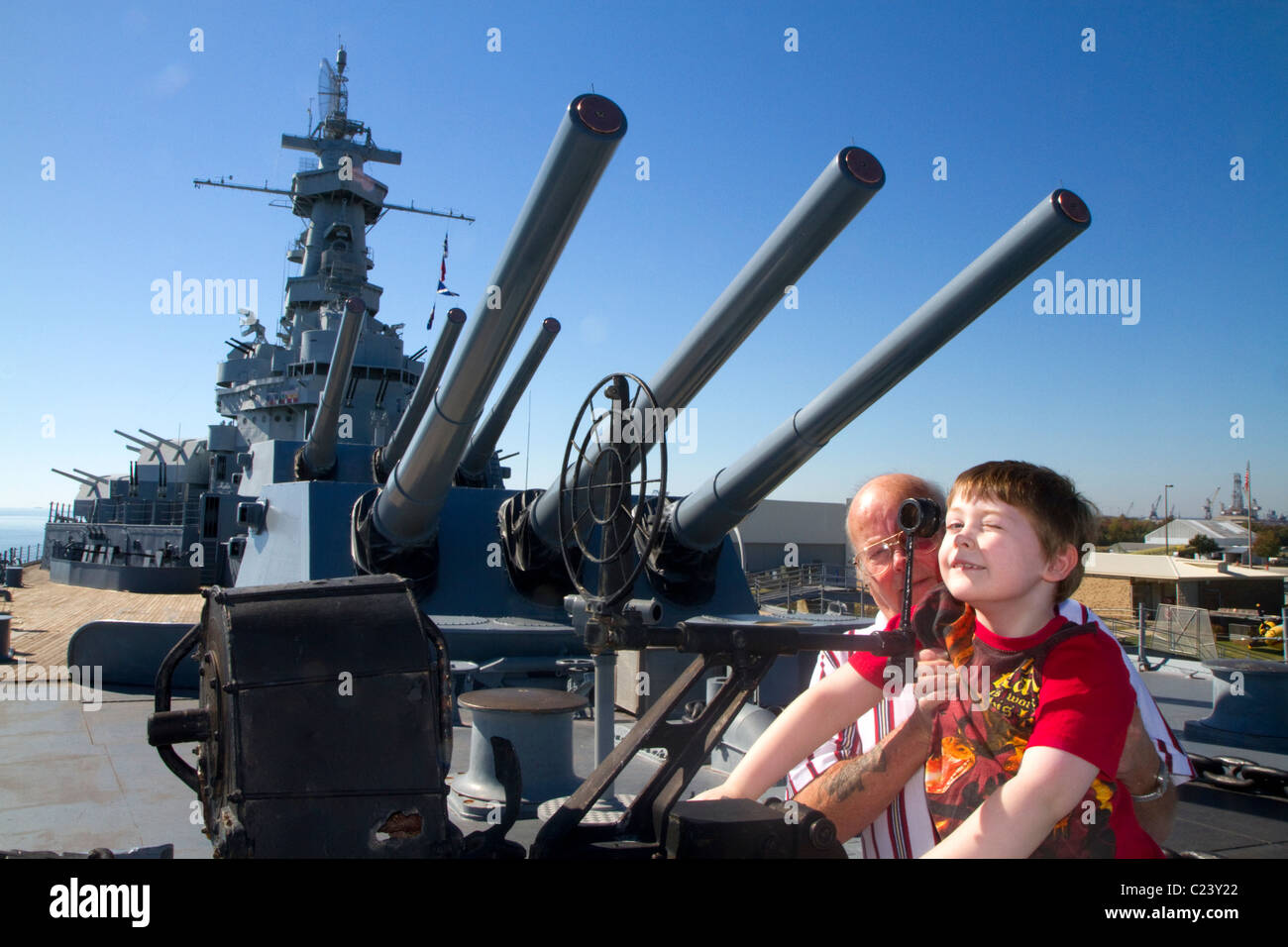 Grandfather and grandson look through the sight of a machine gun at ...