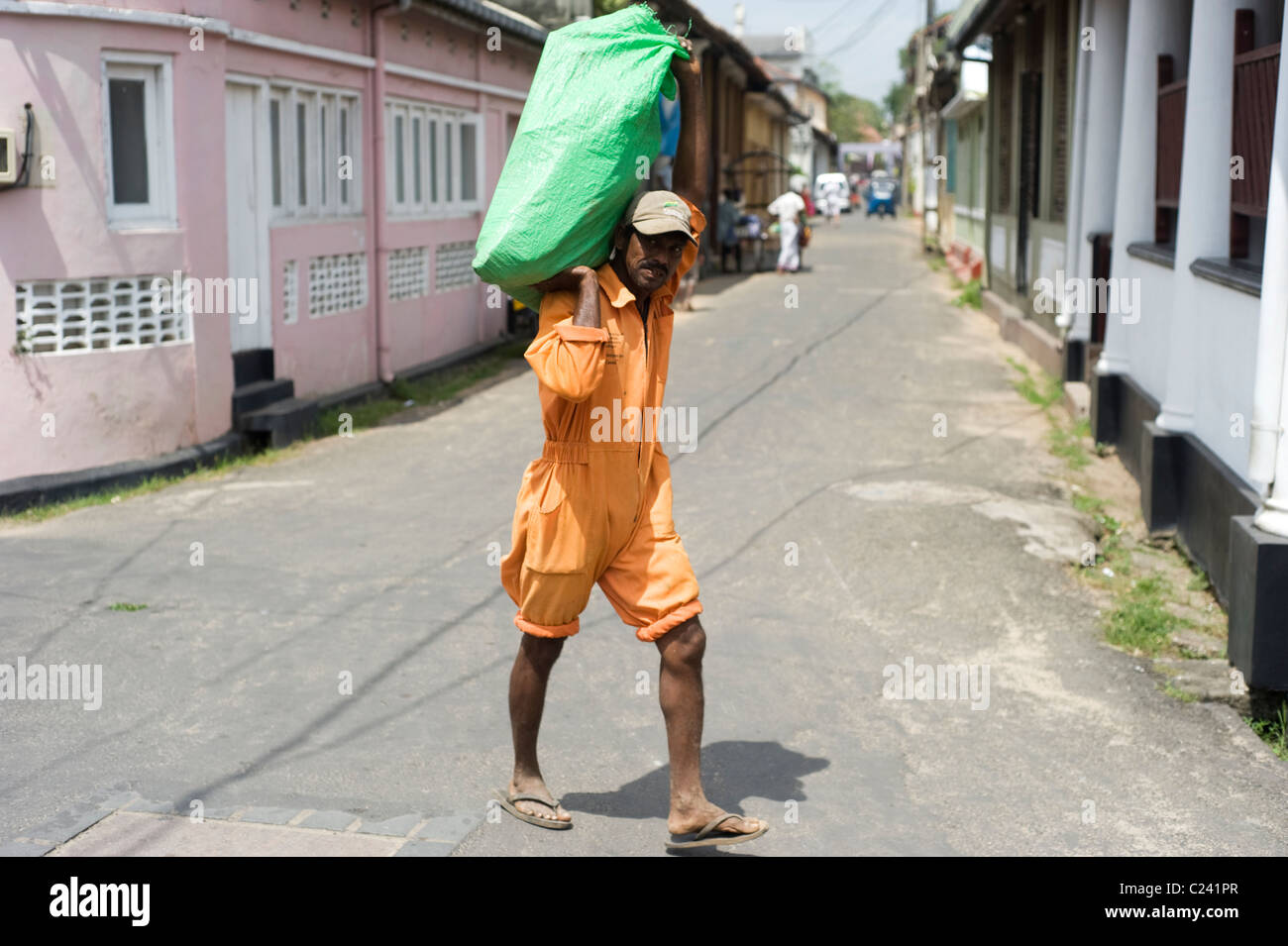Worker with a big packet walking on the street Stock Photo - Alamy