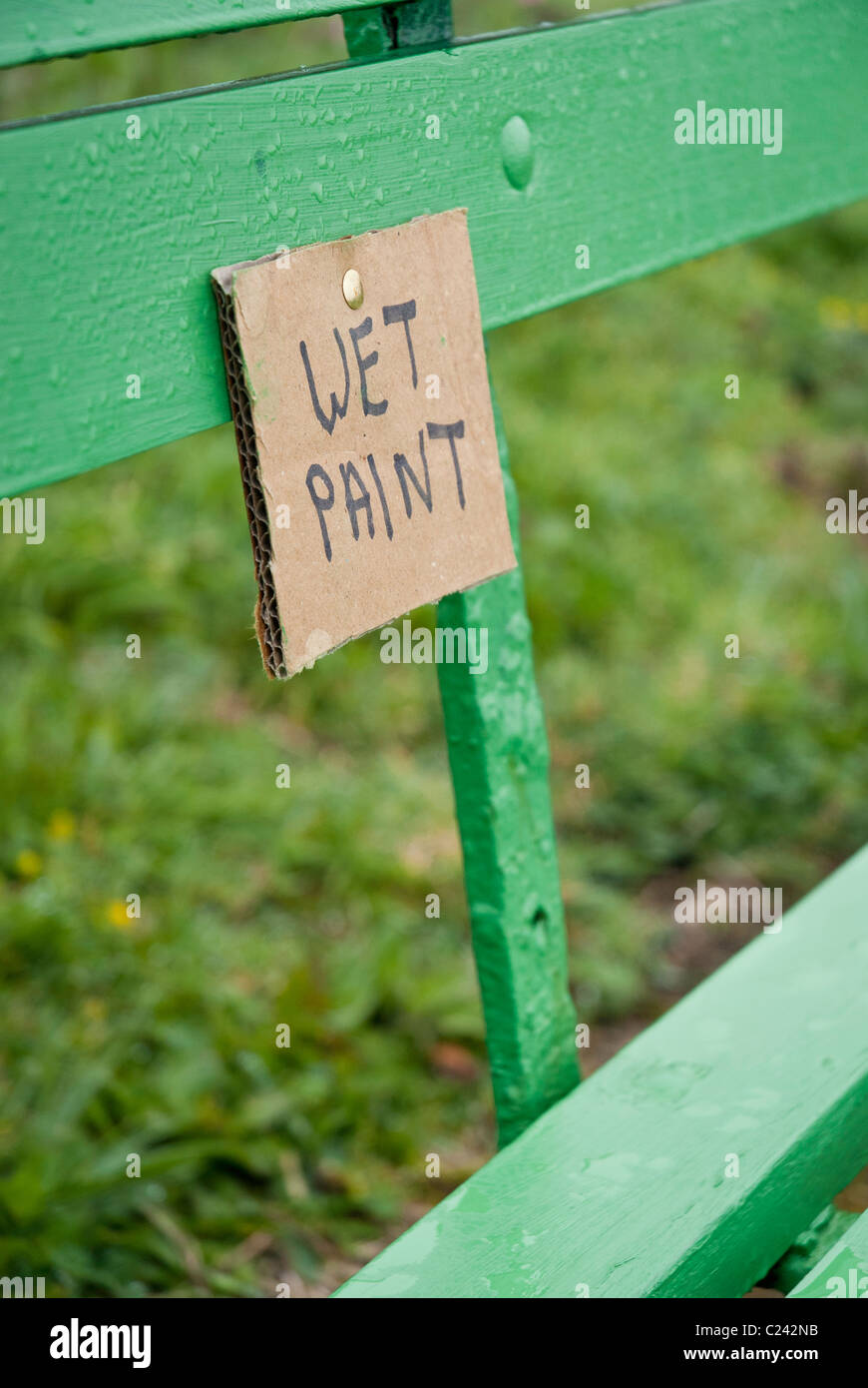 Wet paint sign on public bench Stock Photo - Alamy
