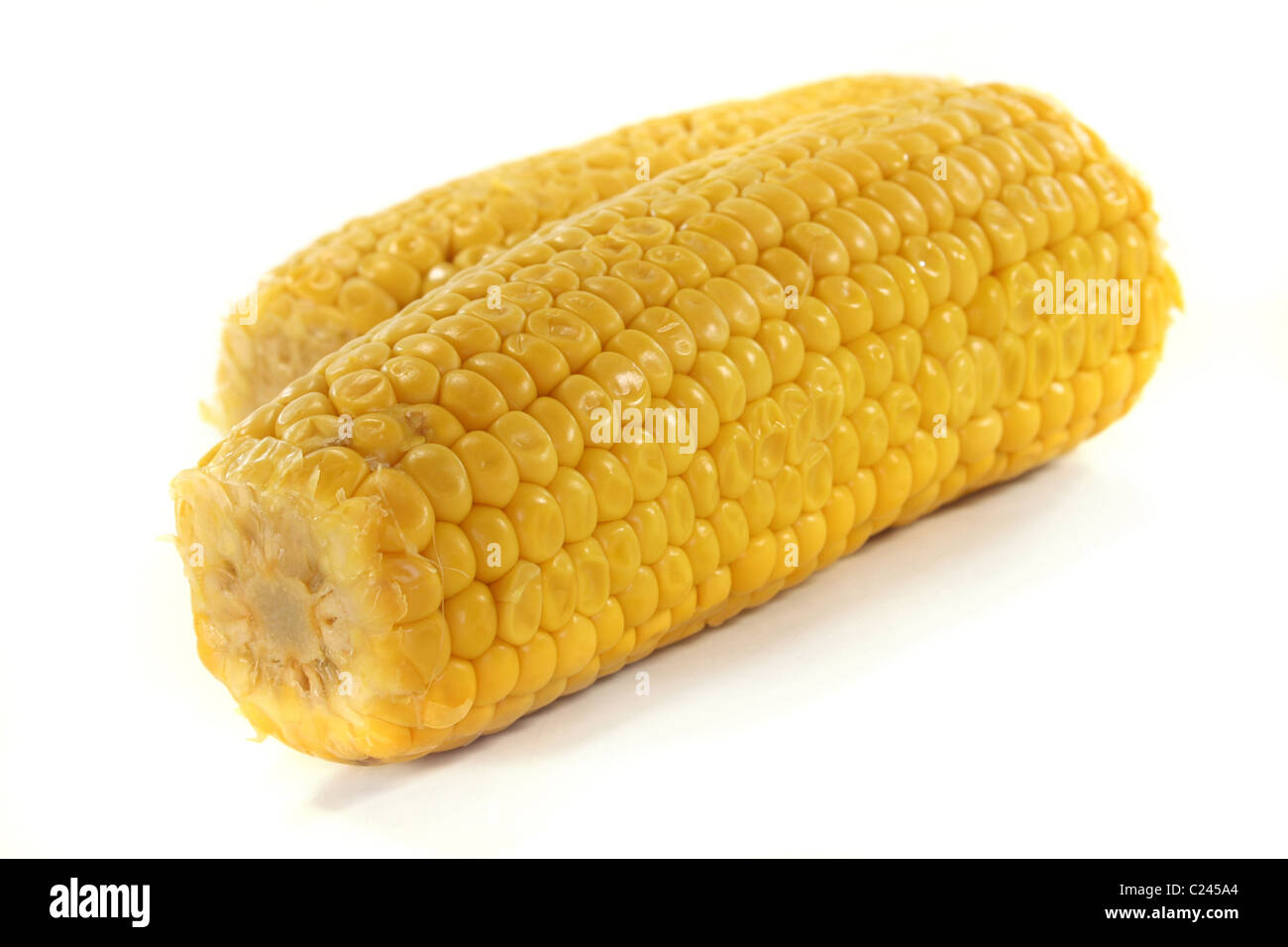 two yellow corn on a white background Stock Photo - Alamy