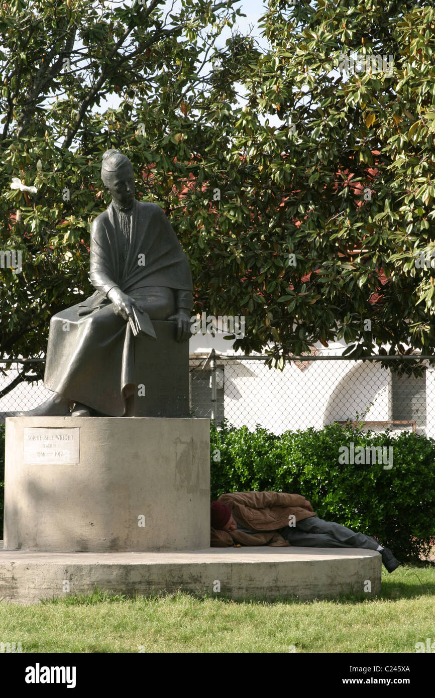Homeless man sleeping next to statue Stock Photo - Alamy