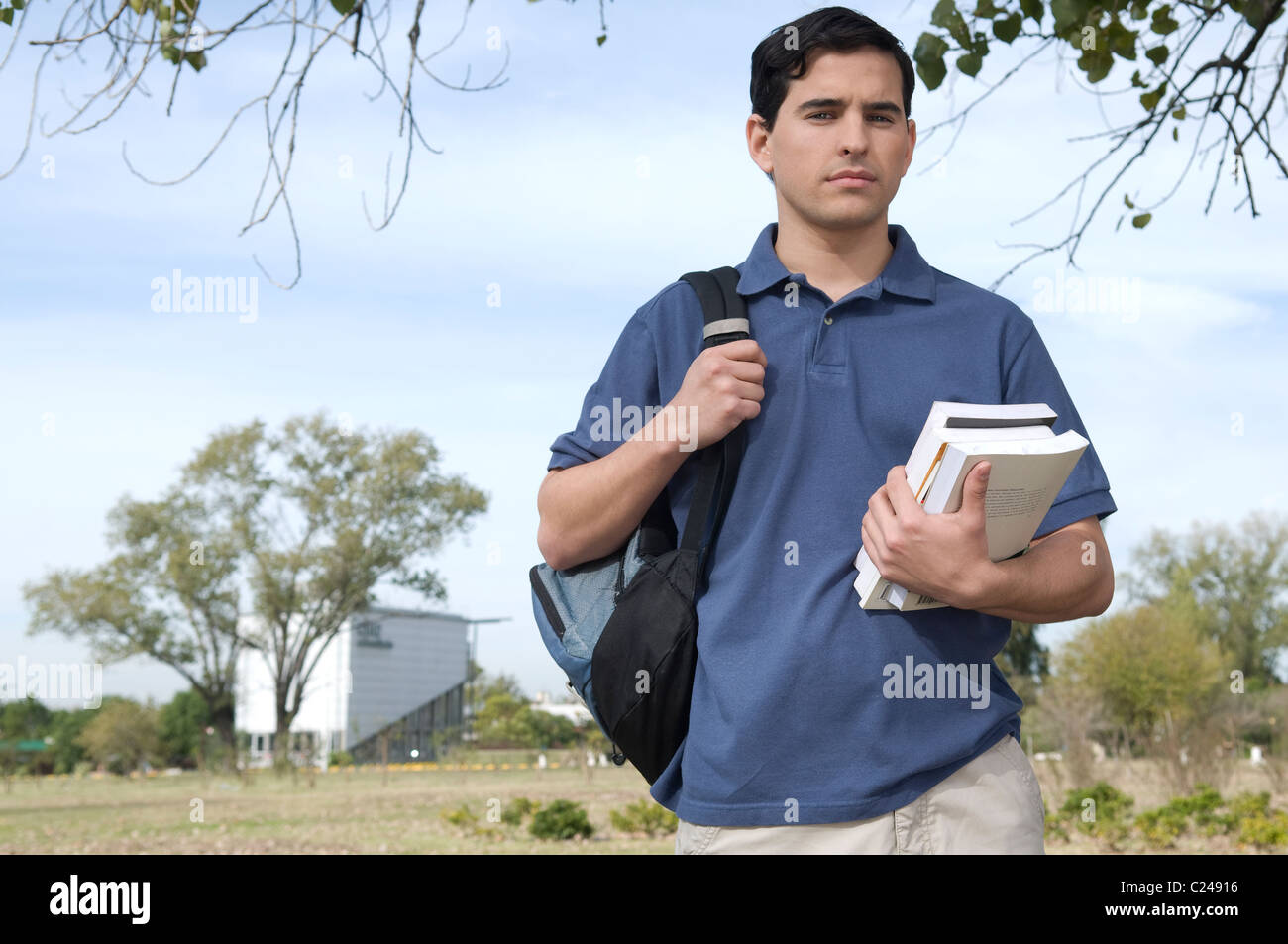 Portrait of university student holding books on campus Stock Photo - Alamy
