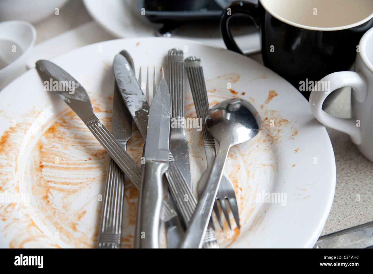 Cutlery resting on a dirty plate ready to be washed England UK Stock ...
