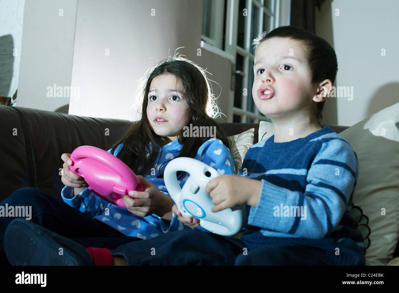 siblings playing game together on the sofa Stock Photo - Alamy