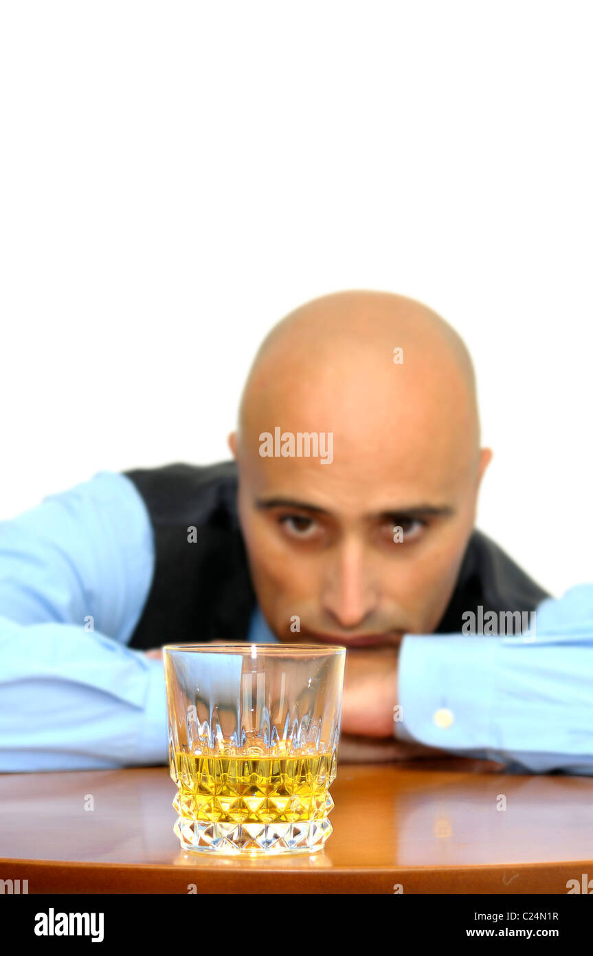 Businessman looking at a glass of alcohol isolated in white Stock Photo ...