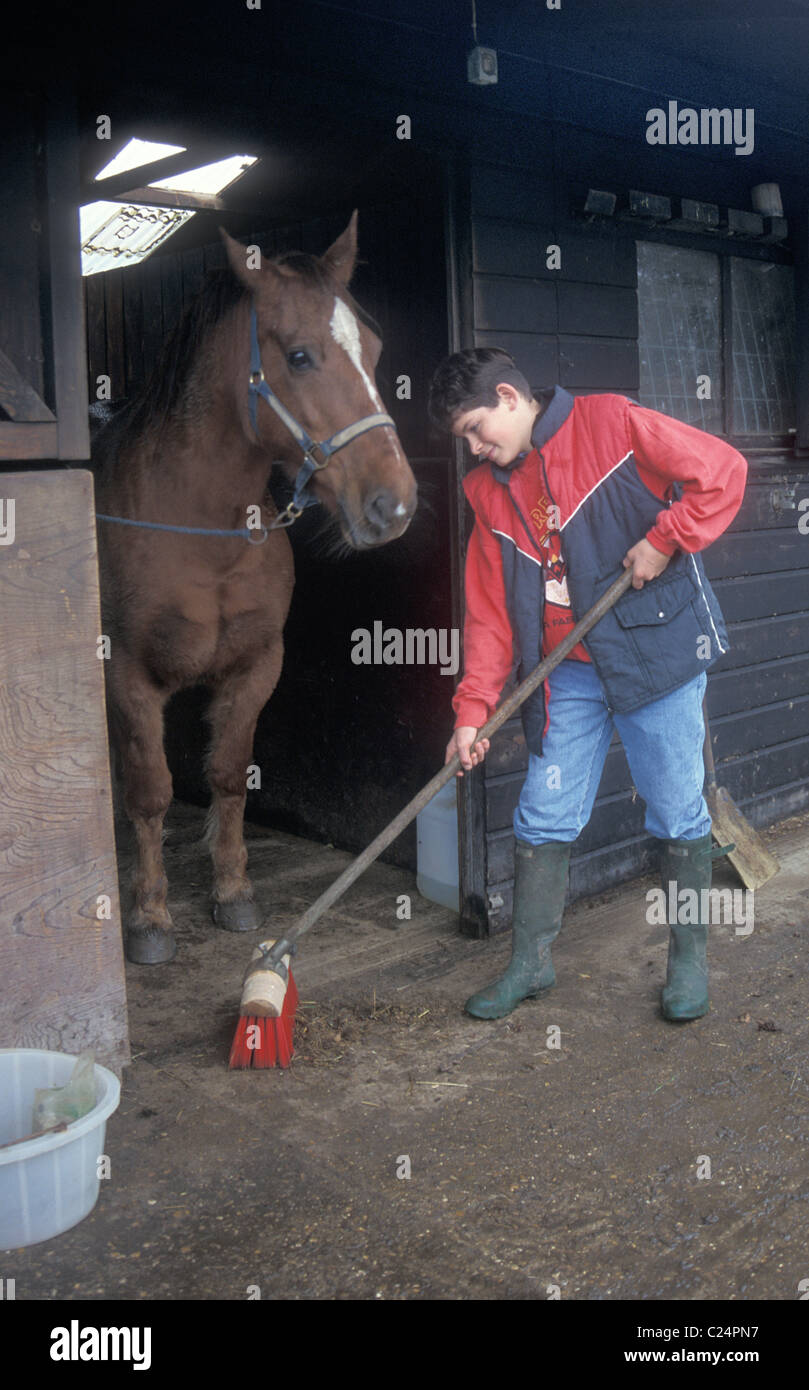 boy sweeping out stable Stock Photo - Alamy