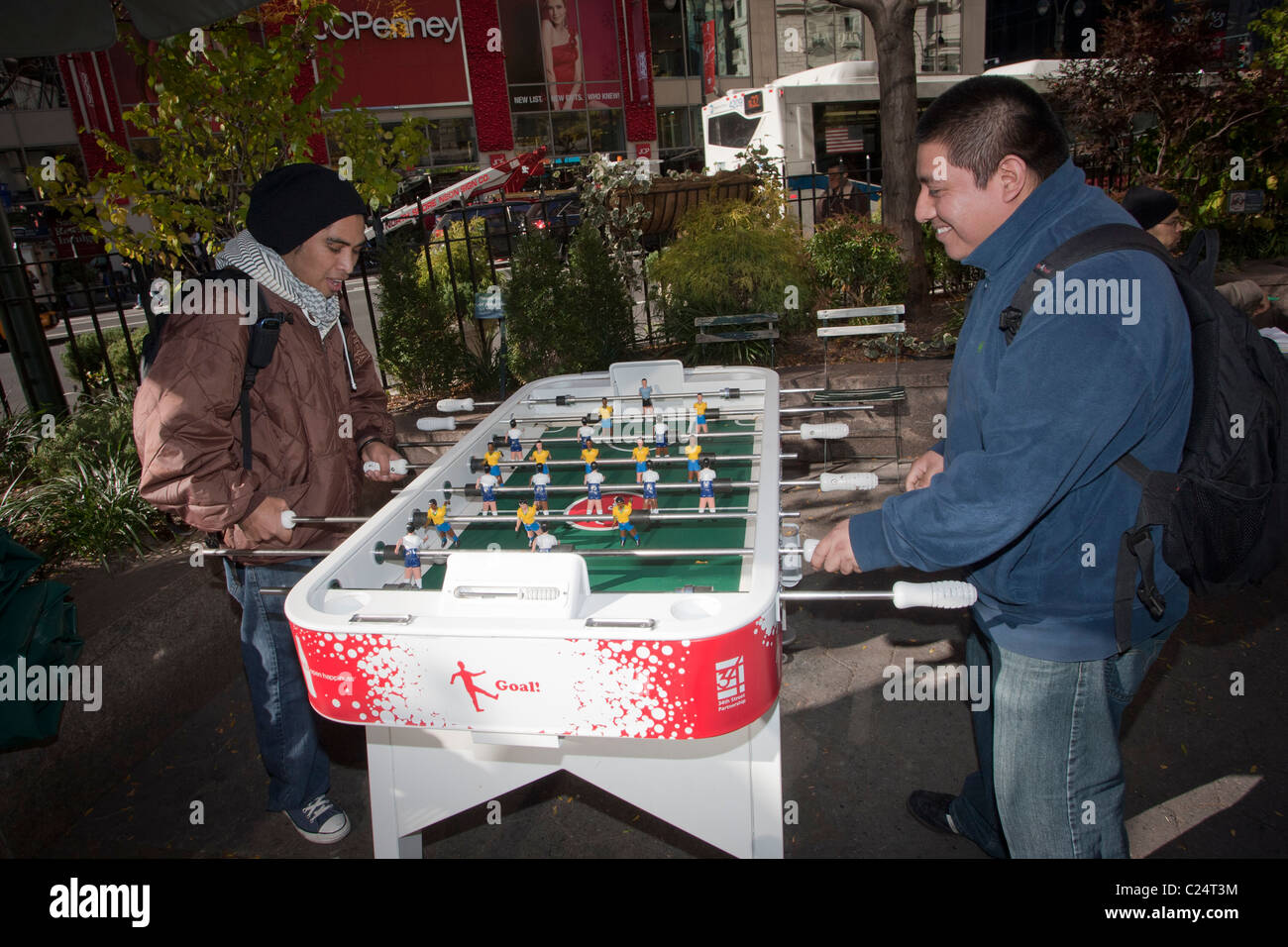 Two visitors to Greeley Square Park in midtown Manhattan play foosball ...