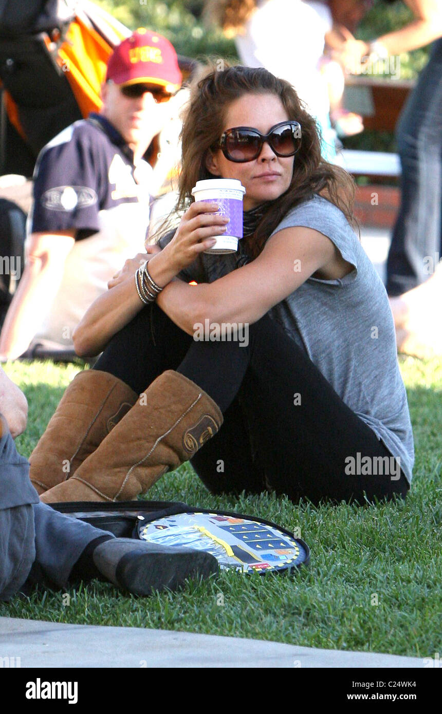 Brooke Burke sits on the grass drinking a hot drink in Cross Creek Park ...