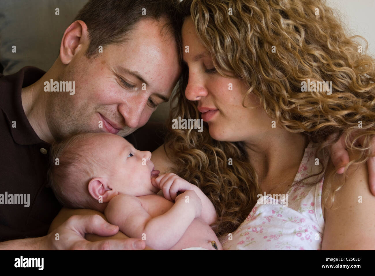 New parents playing with their newborn baby boy Stock Photo - Alamy