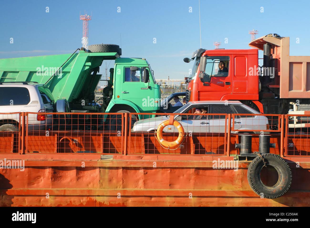 drivers sit in their cars while their raft on a ferry across the Ob ...