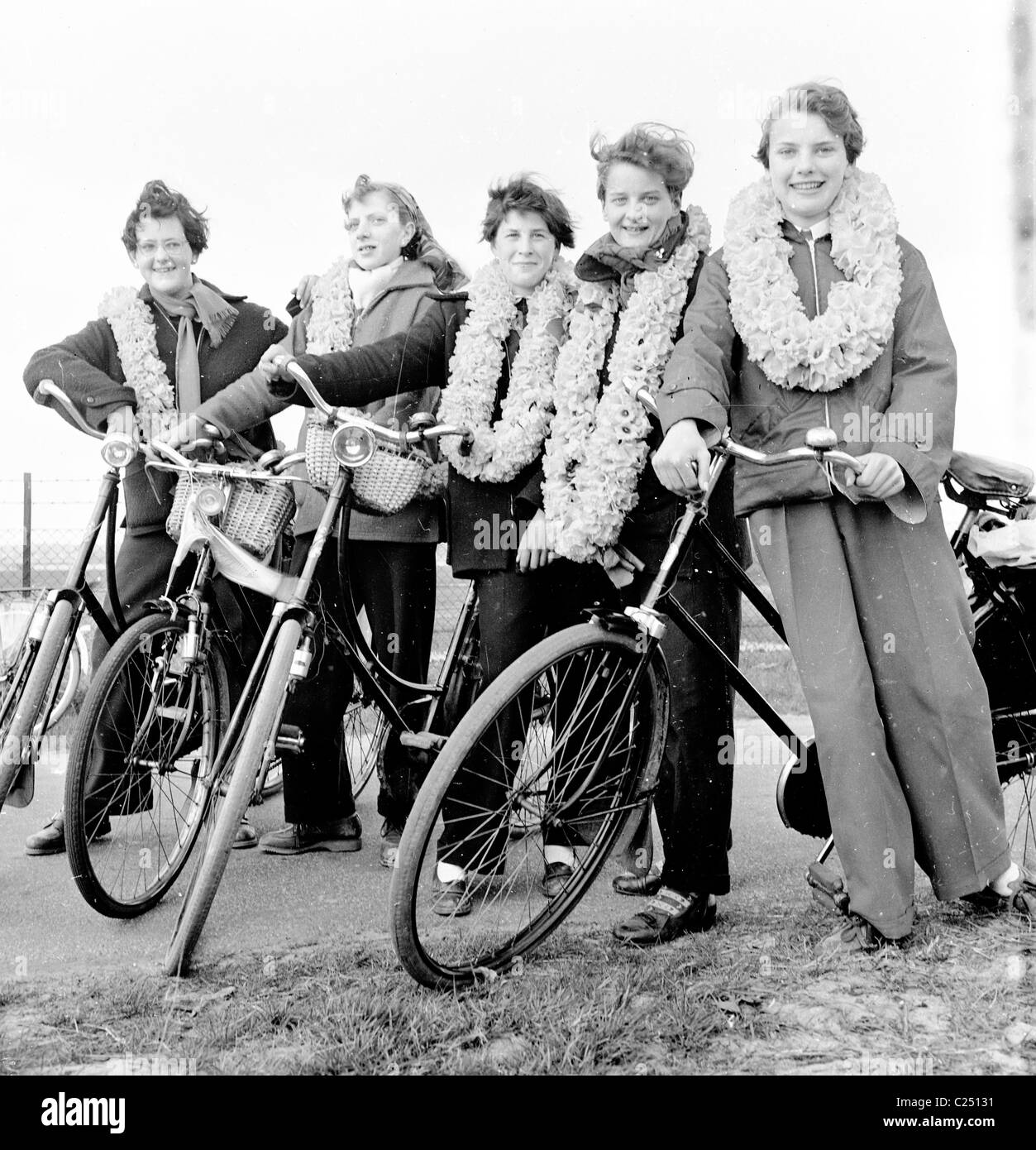 The Netherlands, 1950s. Five female cyclists stand beside their ...
