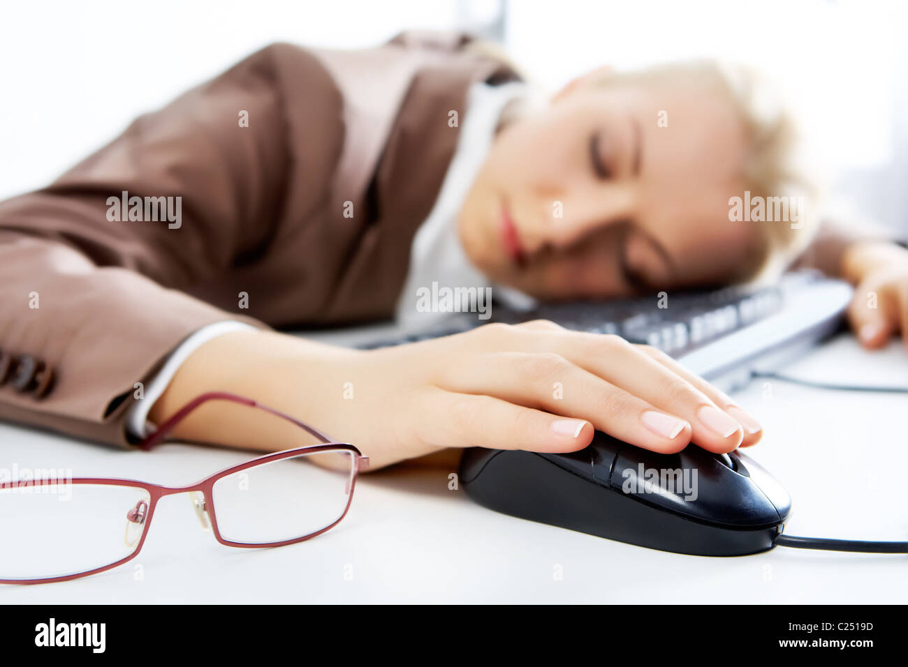 A young businesswoman sleeping on keyboard with a computer mouse Stock ...