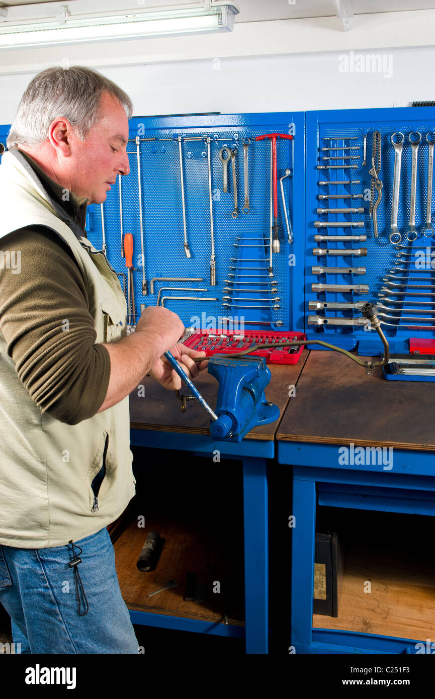 Experienced car mechanic in action at a work-bench Stock Photo - Alamy