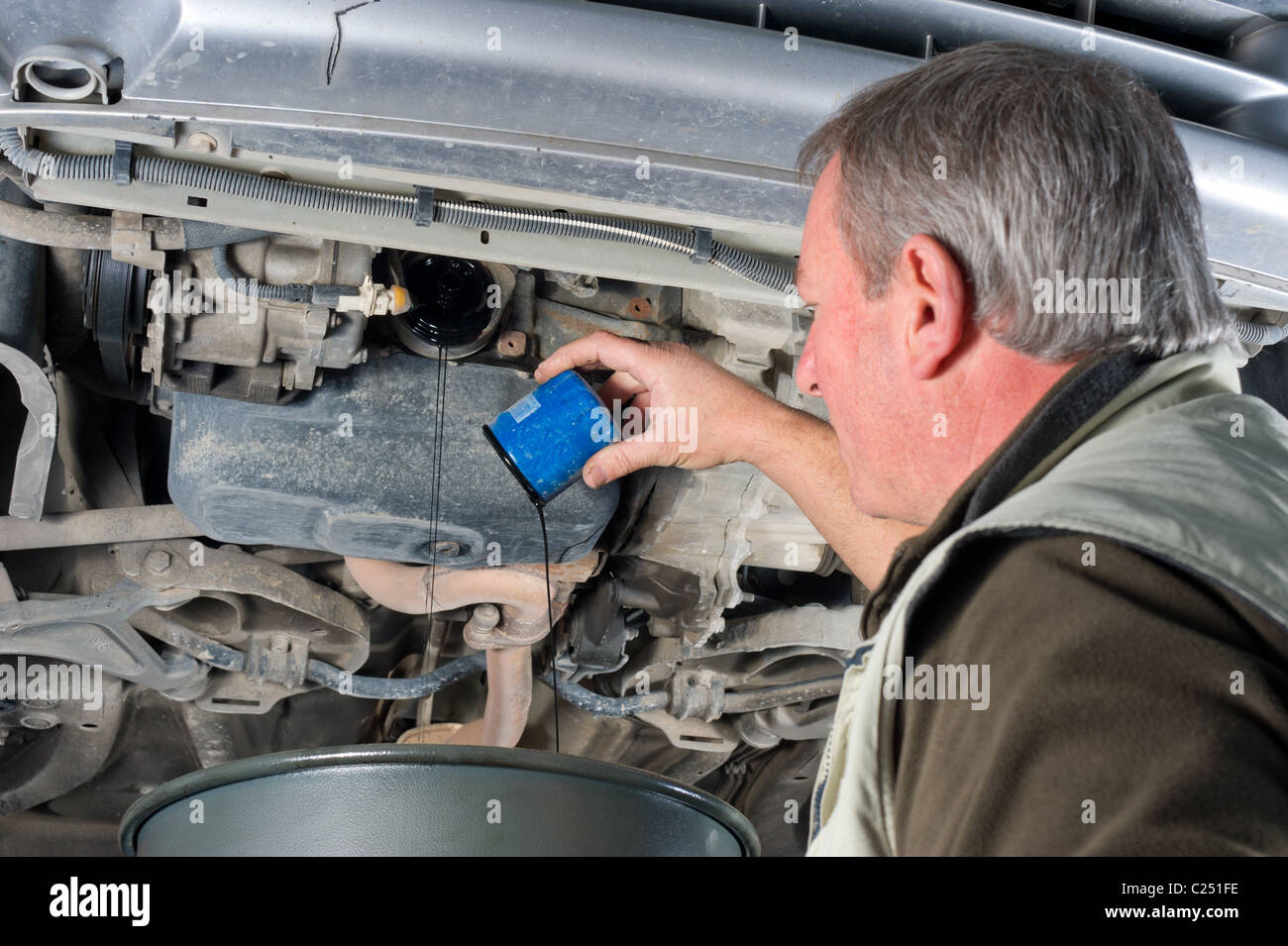Experienced car mechanic changing oil filter on an engine Stock Photo ...