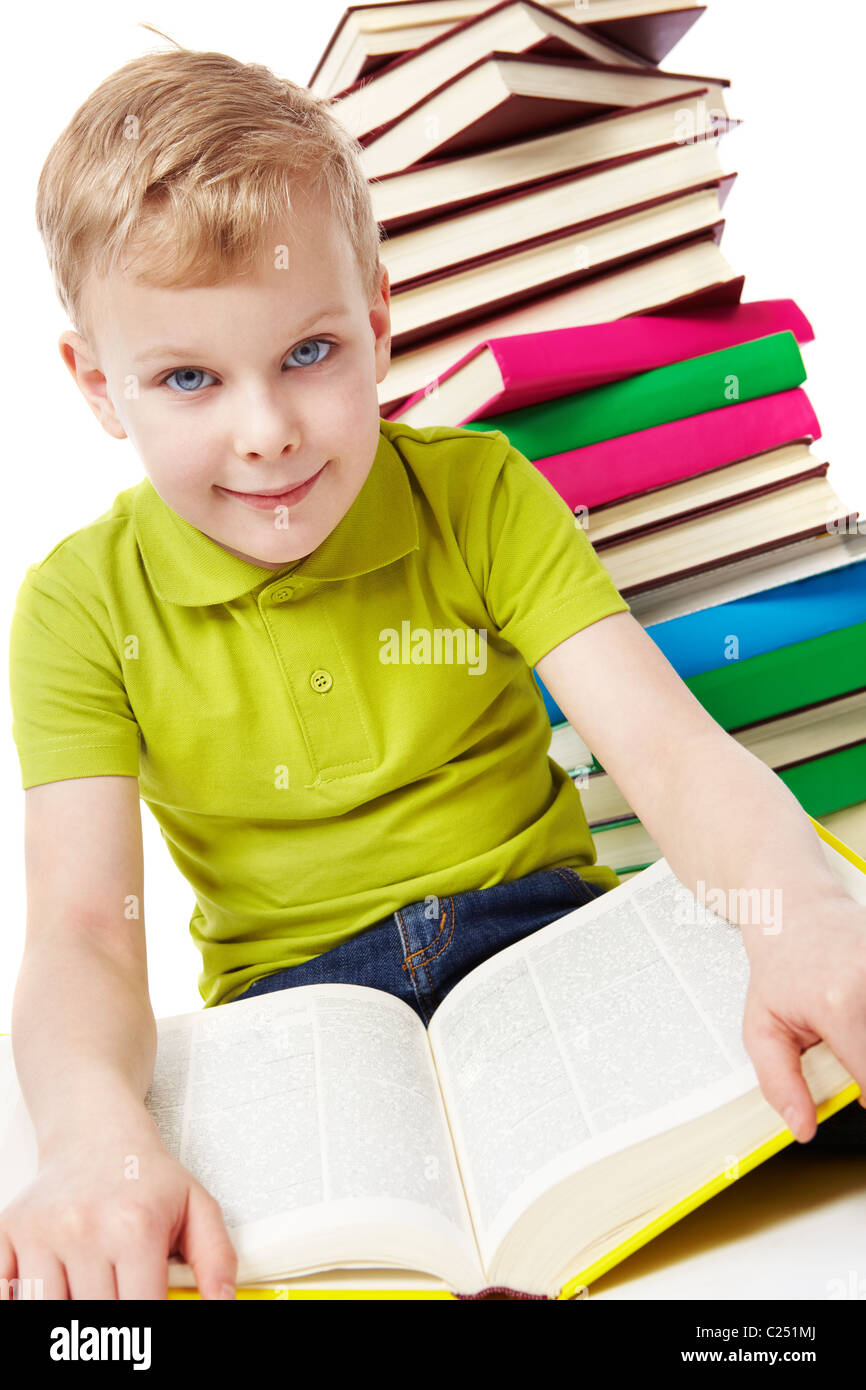 Portrait of a boy sitting with a book at the heap of books Stock Photo ...