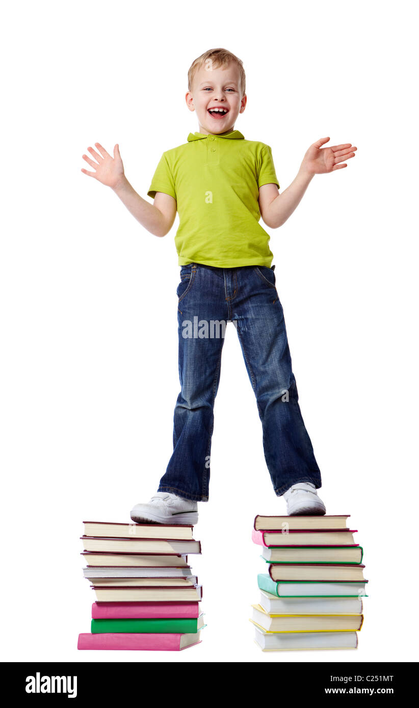 A cheerful boy standing on two heaps of books Stock Photo - Alamy