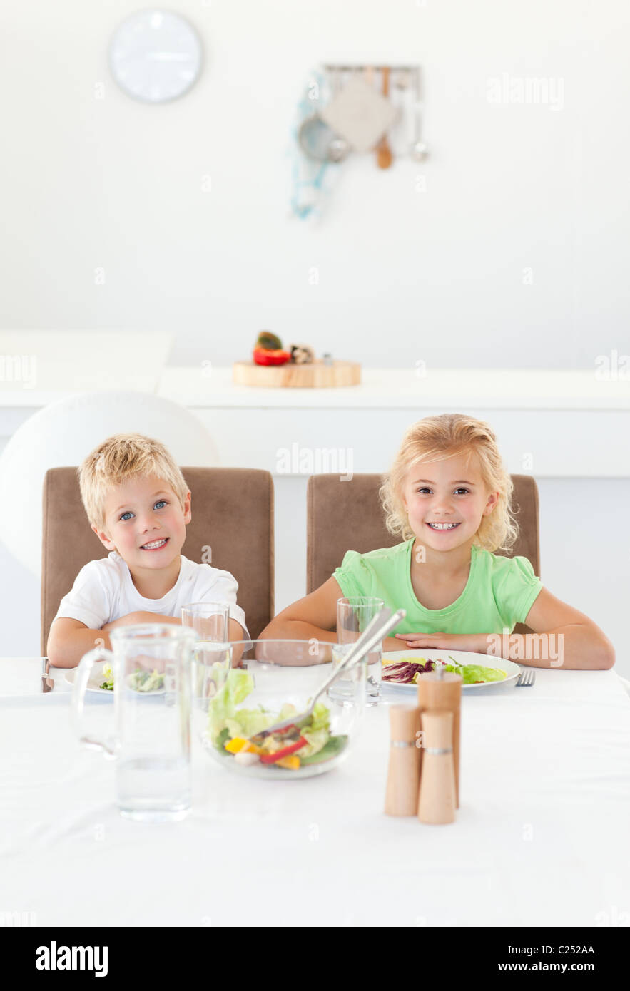 Adorable siblings eating a salad together in the kitchen Stock Photo ...