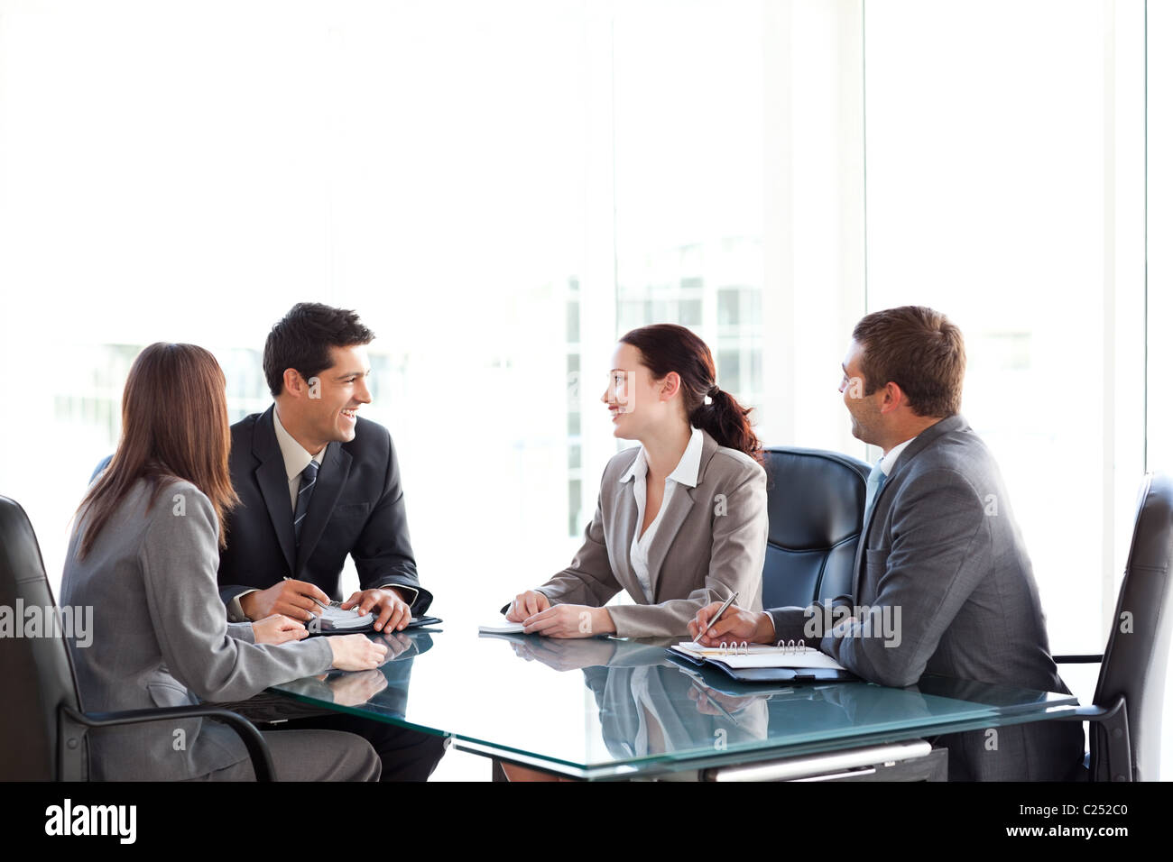 Happy Business team talking together during a meeting Stock Photo - Alamy