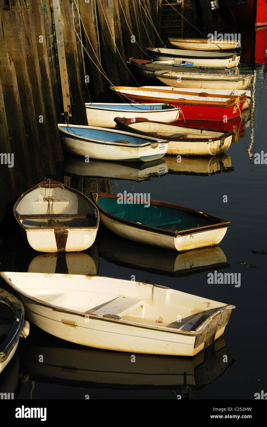 Rowing boats lined up against the pier at West Bay Bridport UK Stock ...