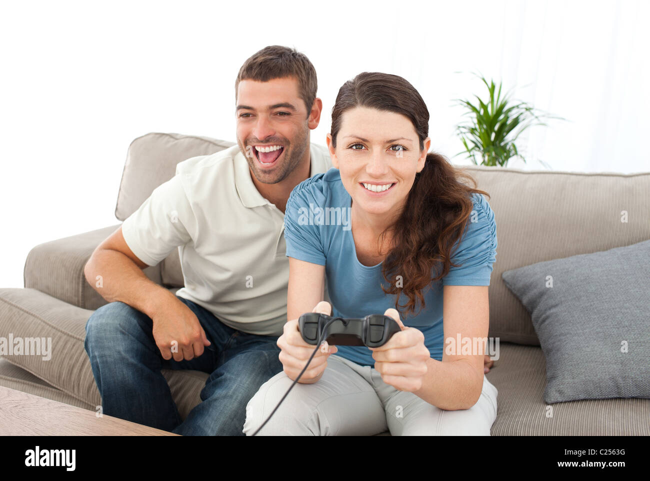 Portrait of a woman playing video game with her boyfriend Stock Photo ...