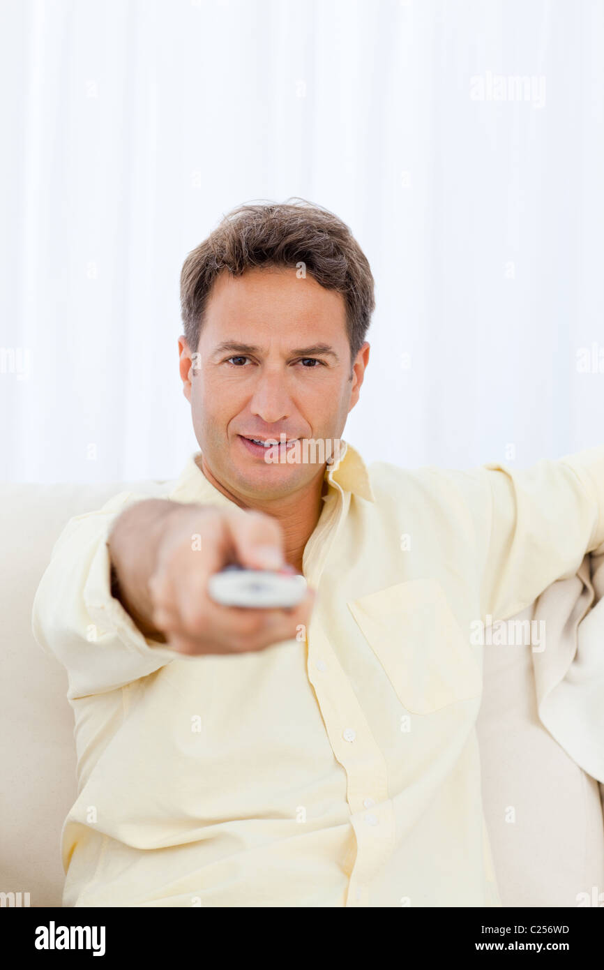 Relaxed man pointing a remote to the camera Stock Photo - Alamy