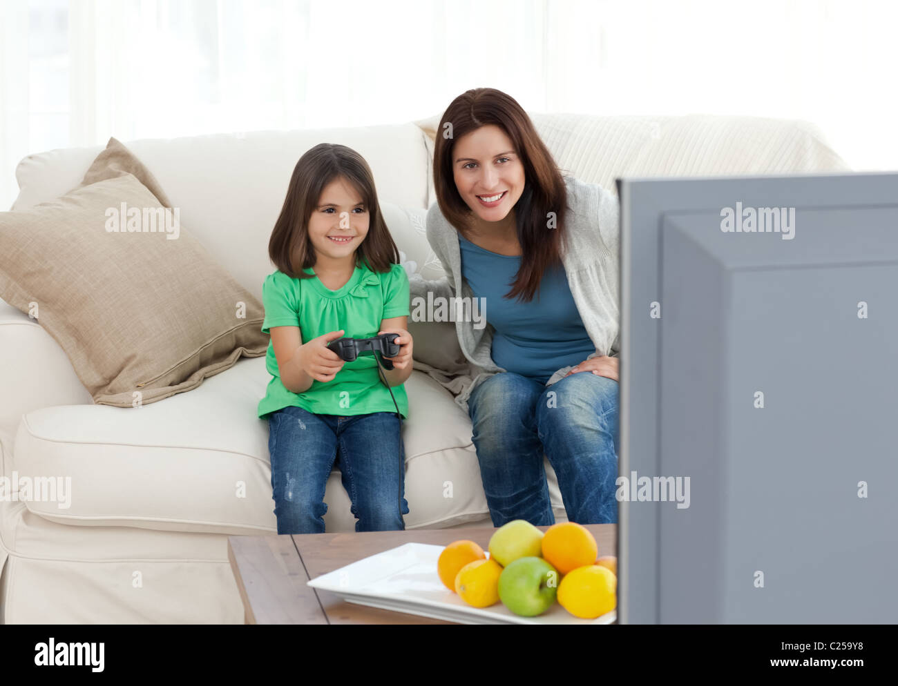 Mom and daughter playing video games together Stock Photo - Alamy