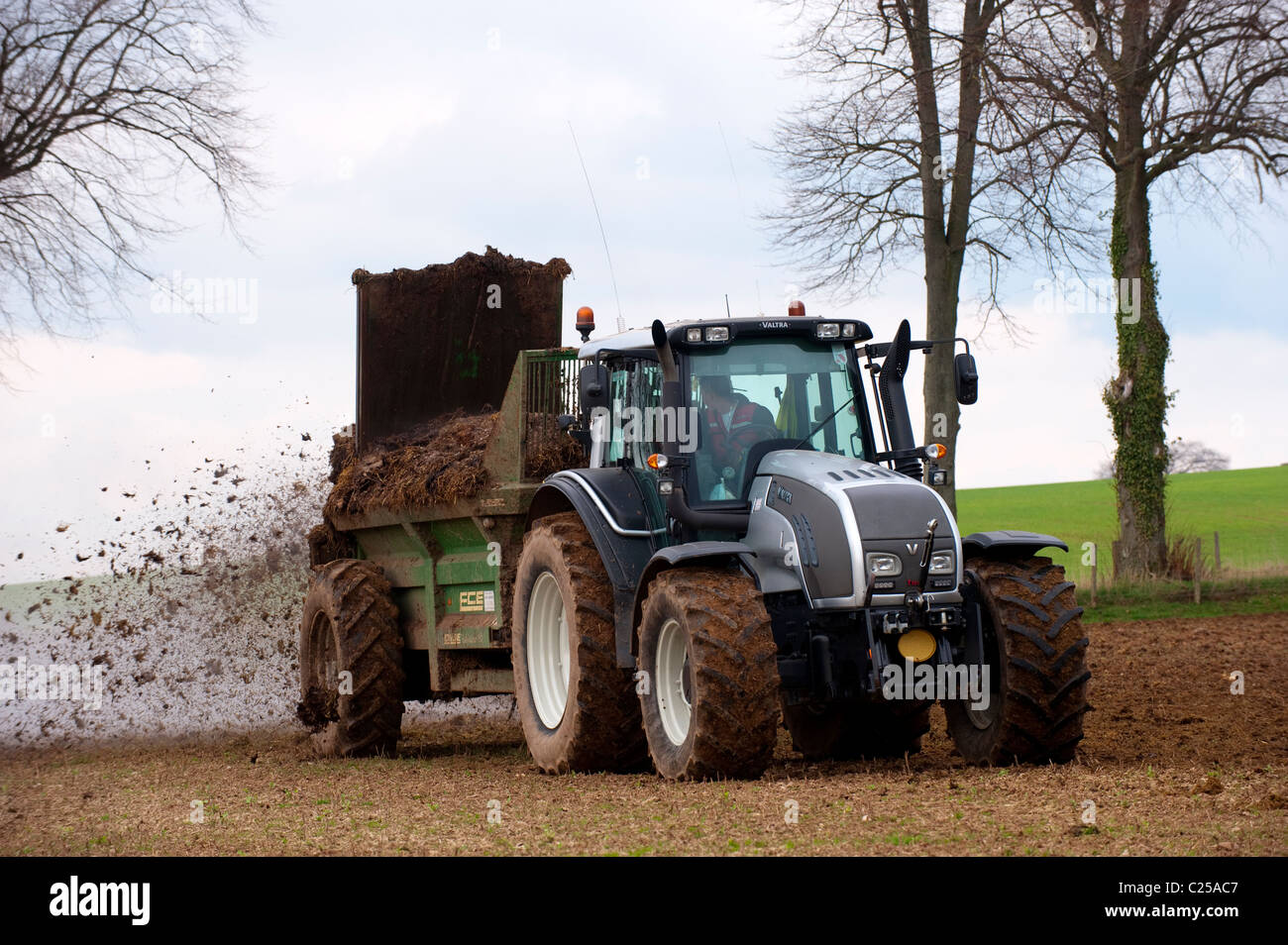 Muck spreading with a Valtra T151 tractor, on a field to be planted ...