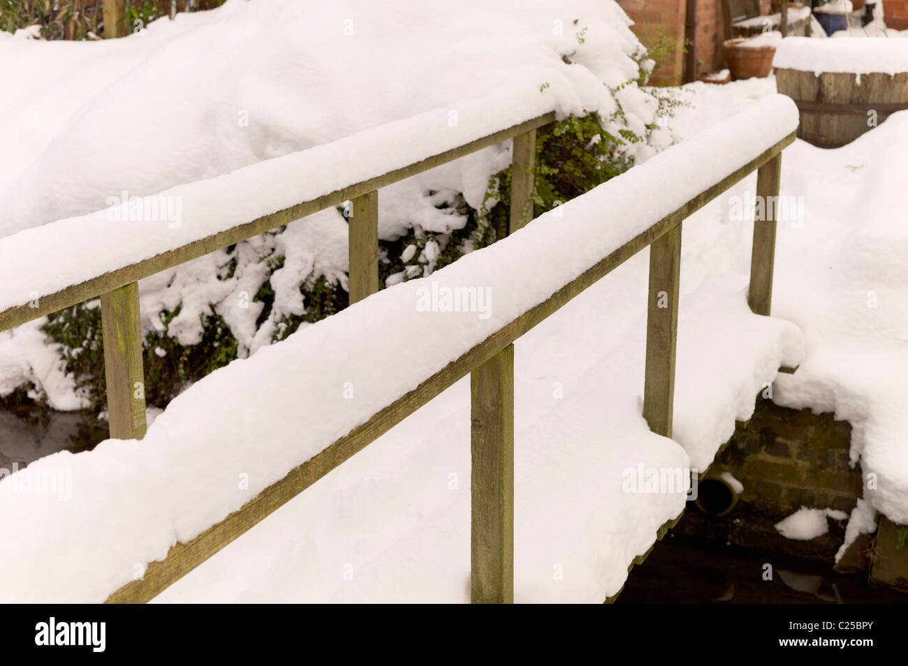 snow winter bridge footbridge stream garden Stock Photo - Alamy