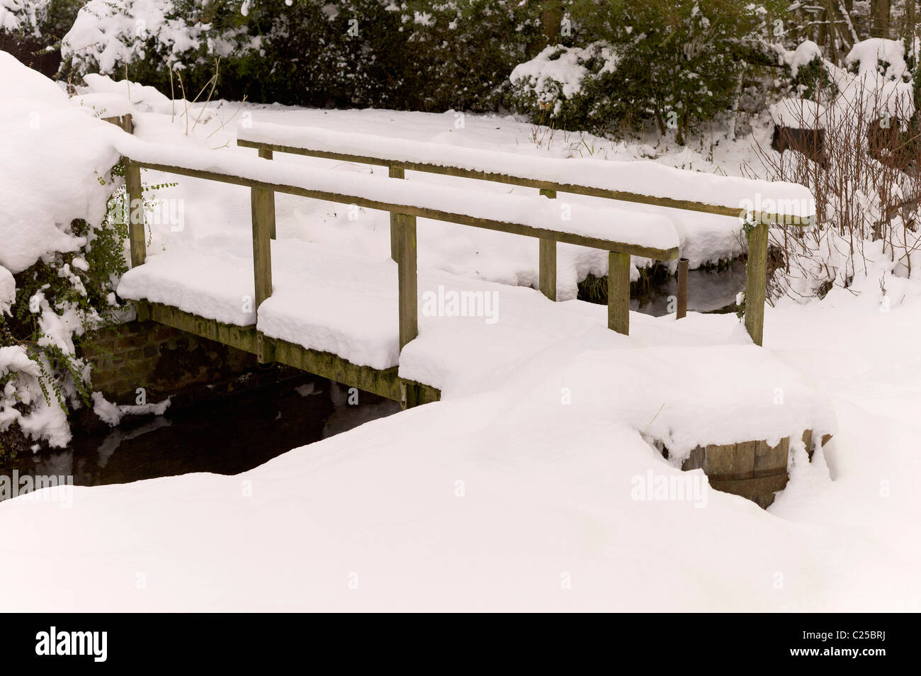 snow winter bridge footbridge stream garden Stock Photo - Alamy
