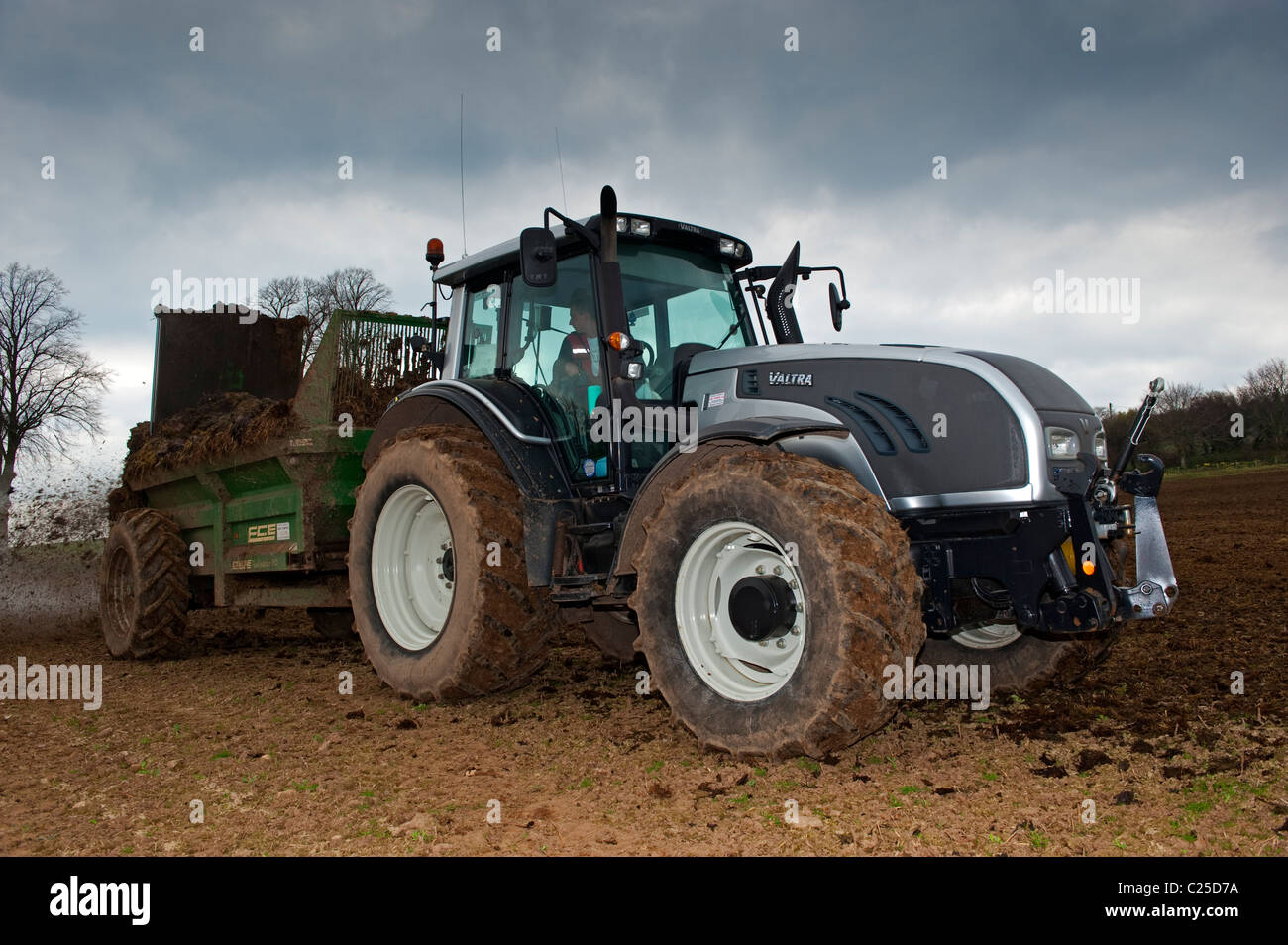 Muck spreading with a Valtra T151 tractor, on a field to be planted ...